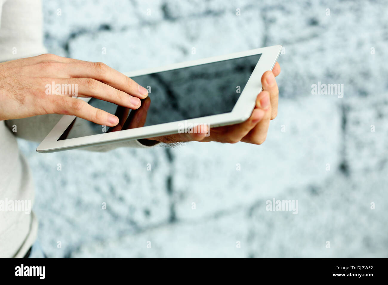 Closeup image of male hand touching display of tablet computer near the ...