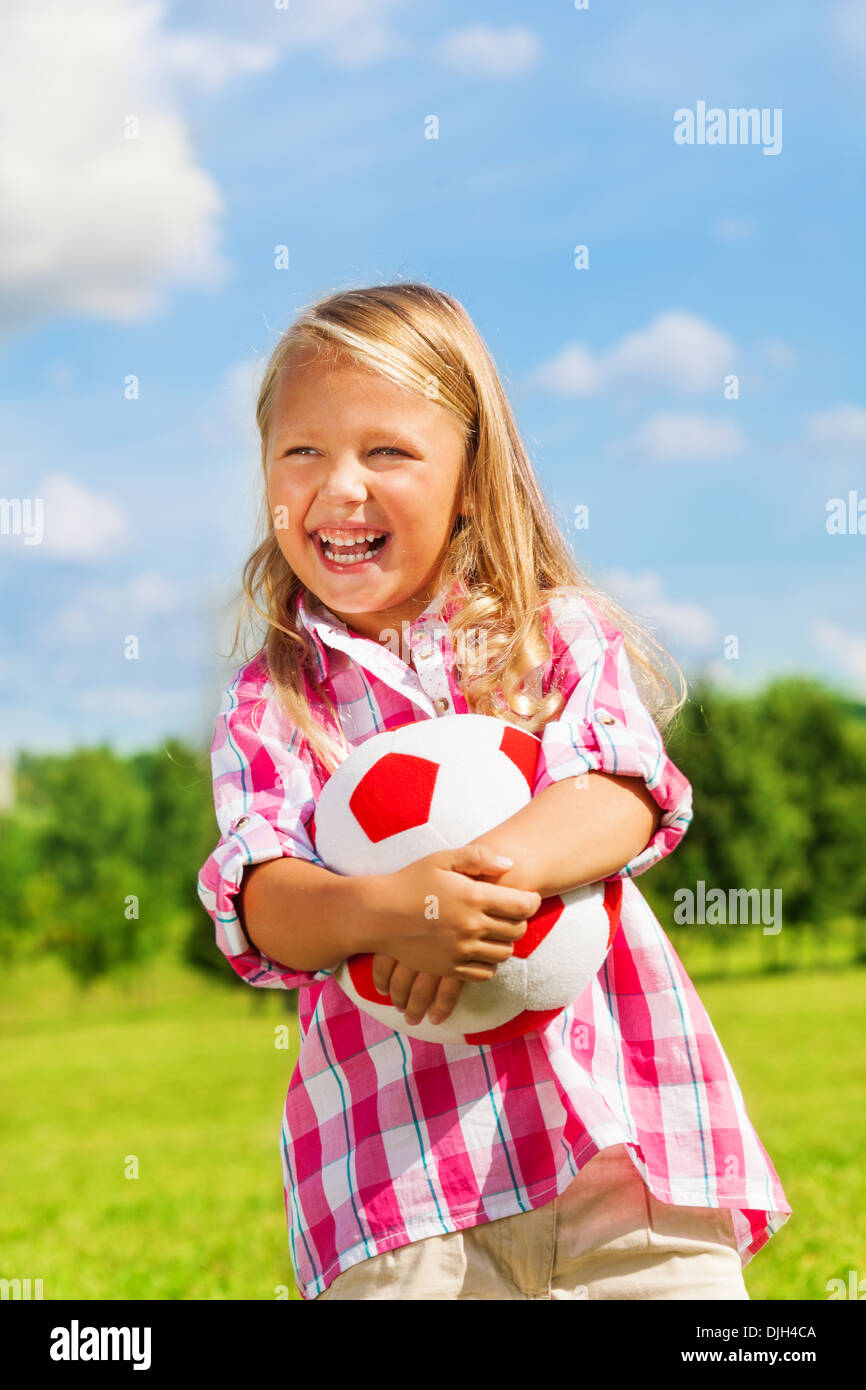 Nice little 6 years old blond cute girl in pink shirt holding soccer ...