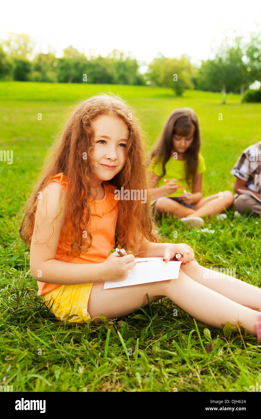 Girls sitting and drawing outside in the Stock Photo - Alamy
