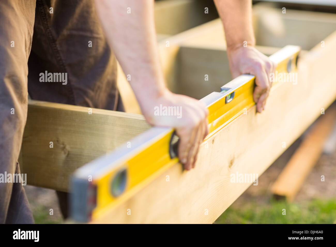 Carpenter's Hands Checking Level Of Wood At Site Stock Photo - Alamy