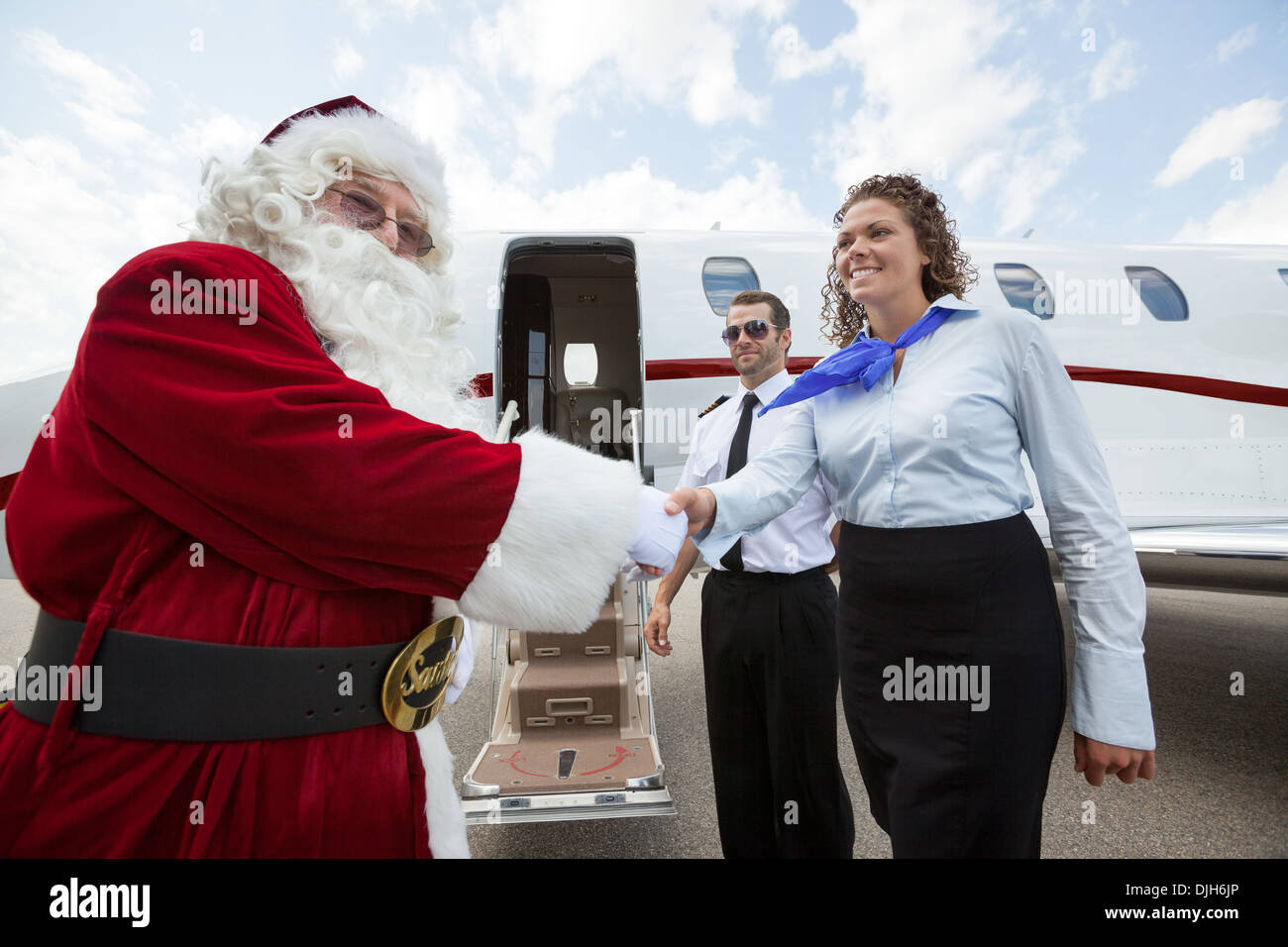 Airhostess And Pilot Welcoming Santa Against Private Jet Stock Photo ...