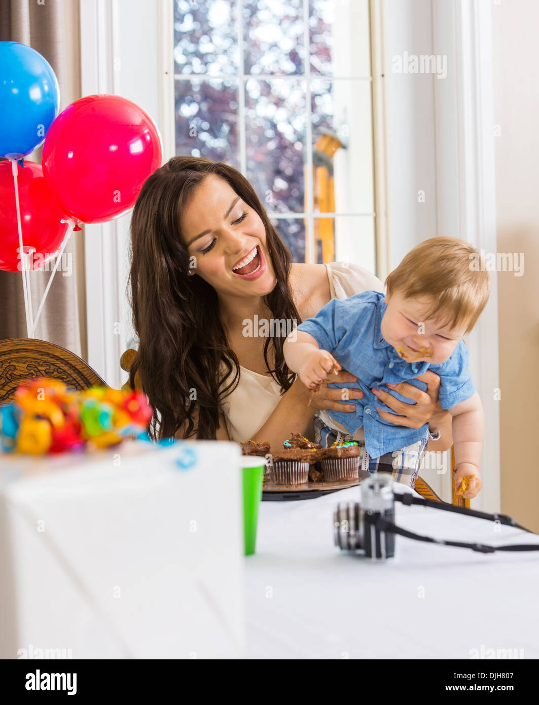 Mother Holding Boy With Messy Hands Covered With Cake Icing Stock Photo ...