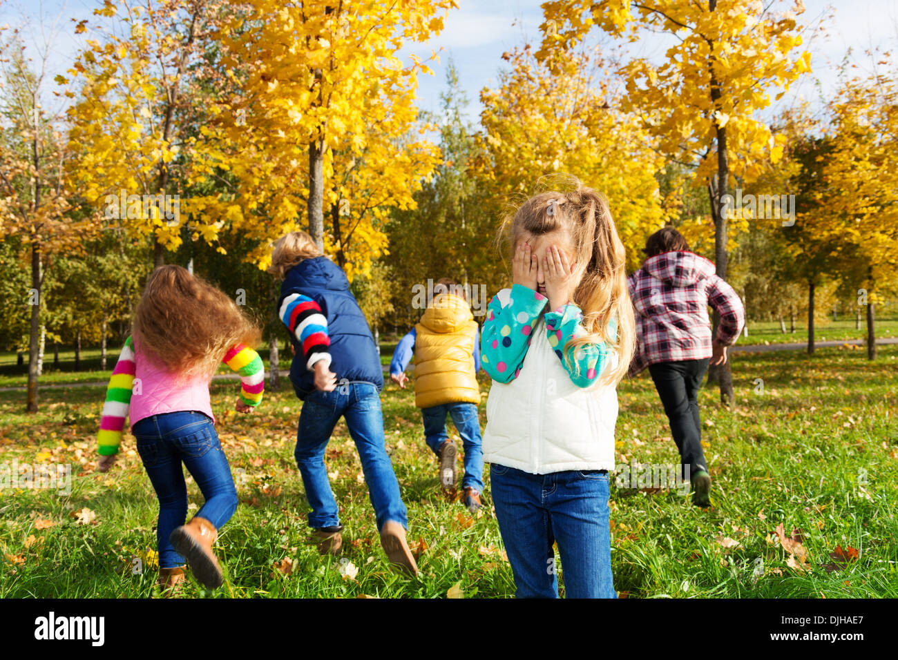 Kids playing hide and seek in autumn park Stock Photo - Alamy
