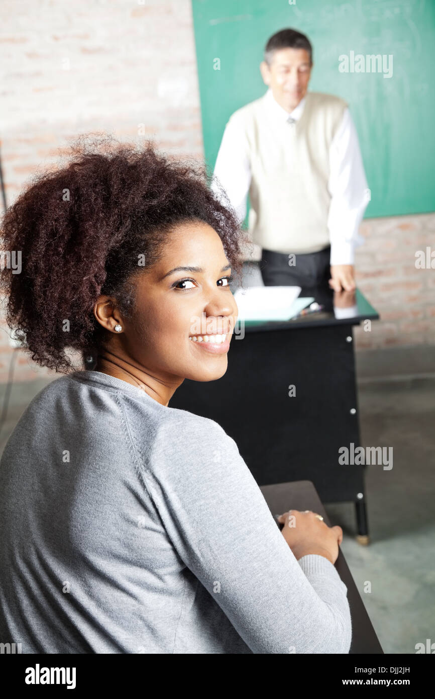Student With Professor Standing In Background At Classroom Stock Photo ...