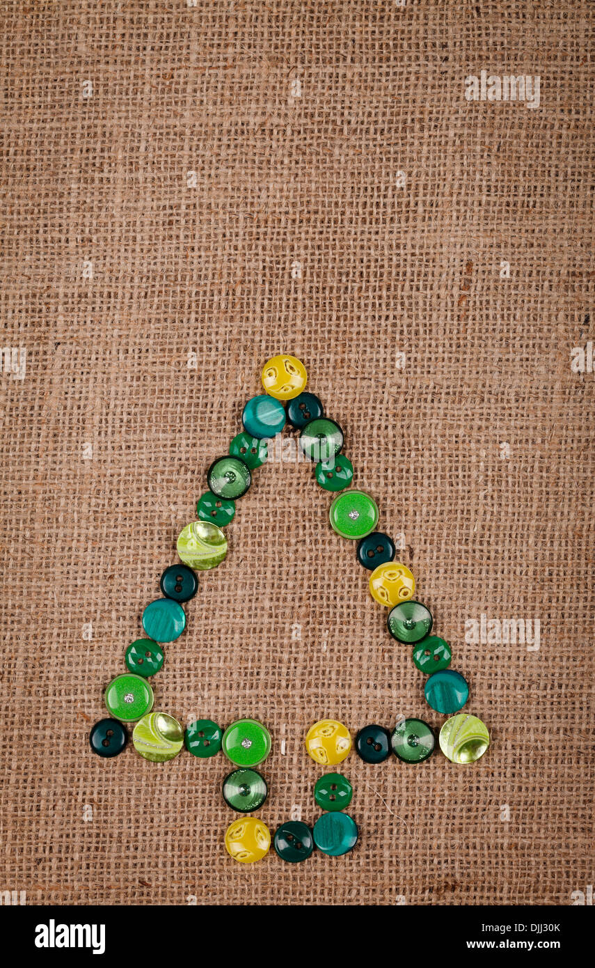 Contour of Christmas tree made of buttons, over burlap background Stock ...