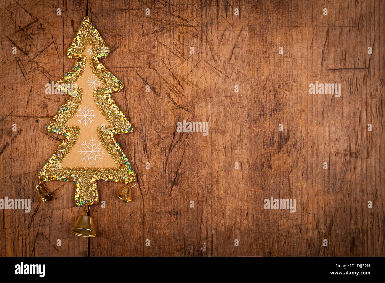 Christmas tree shape decoration with three golden bell on old scratched ...