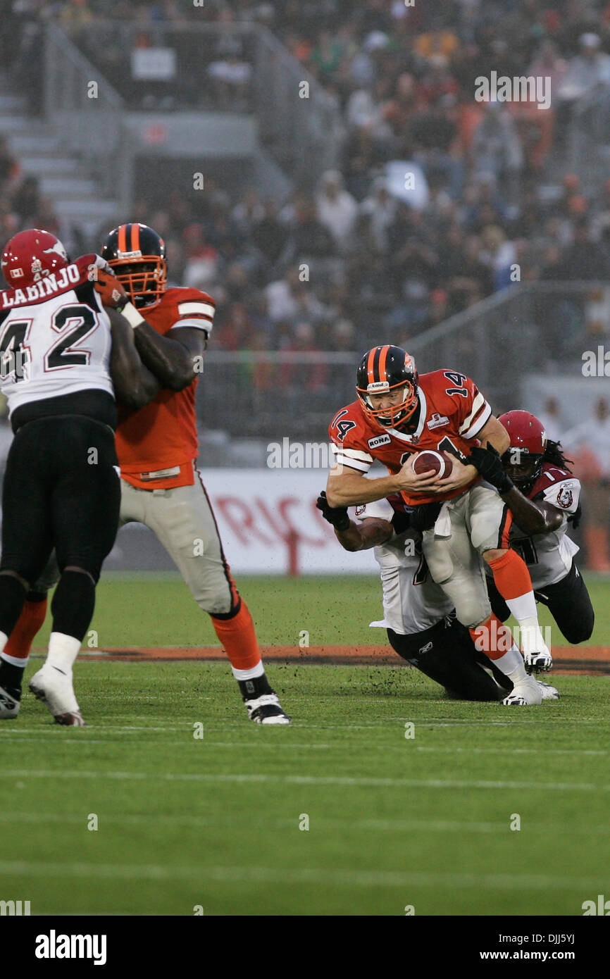 7th of August: BC Lions #14 QB Travis Lulay is being tackled by Calgary ...