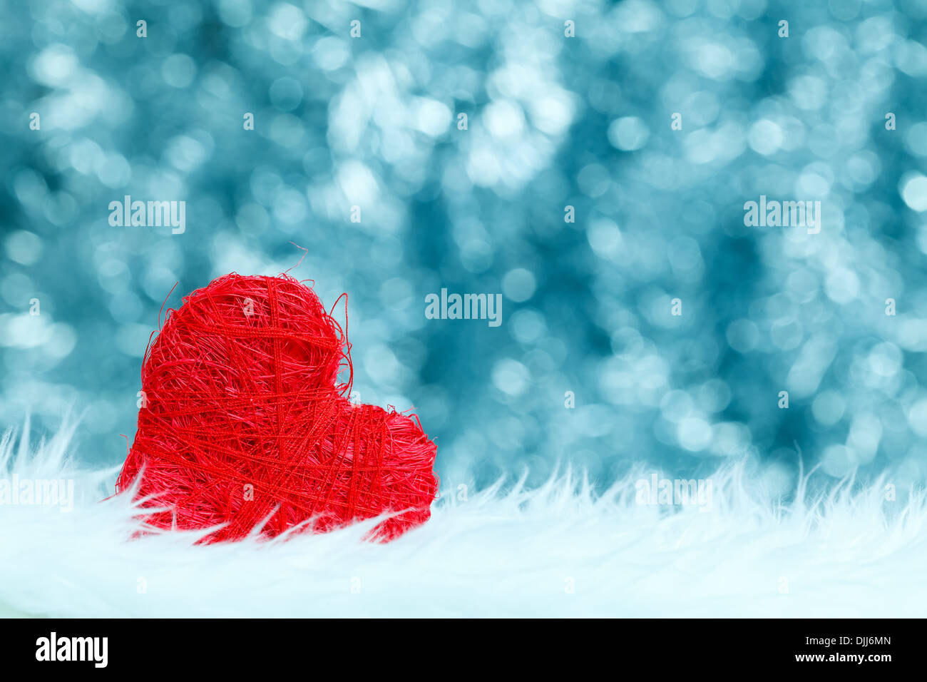 Lonely red string heart on the left side over blue shiny background ...