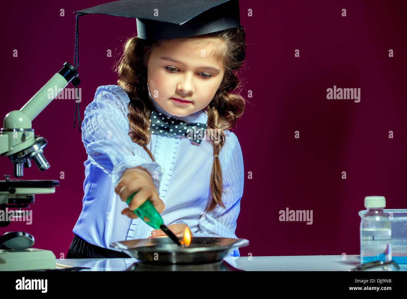 Concentrated funny girl sets fire to burner in lab Stock Photo - Alamy