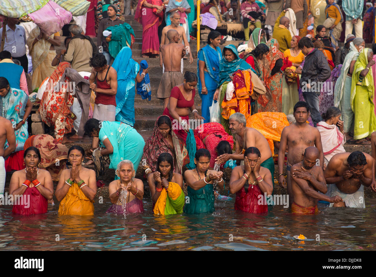 A group of Hindu believers pray at dawn submerged in the waters of the ...