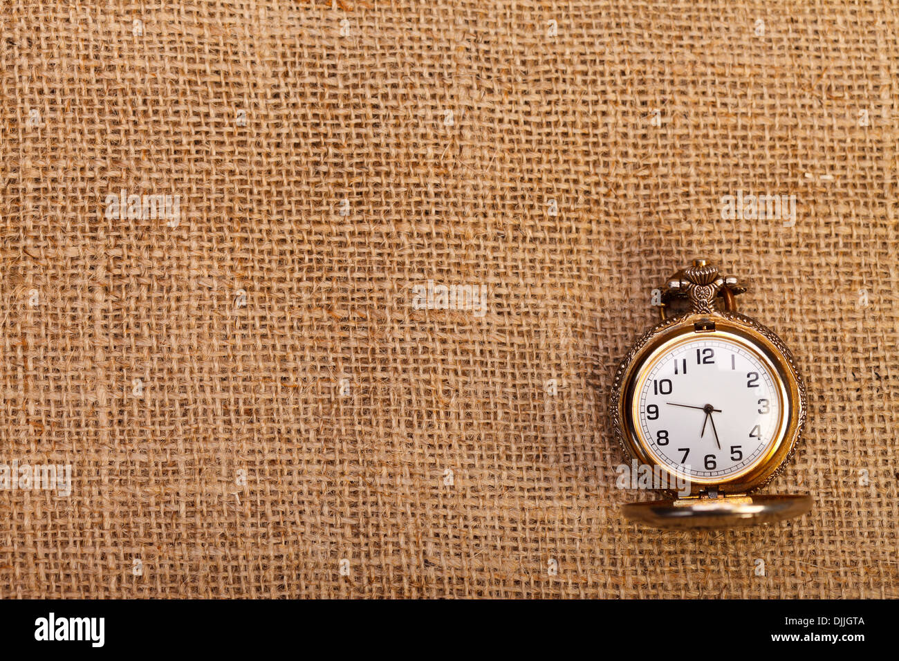 Antique pocket watch on burlap texture background Stock Photo - Alamy