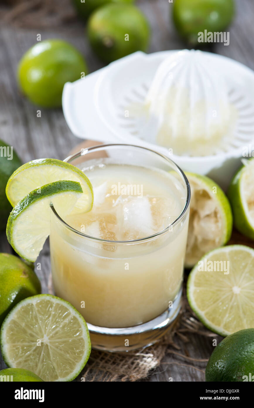 Glass with fresh made Lime Juice on vintage background Stock Photo - Alamy