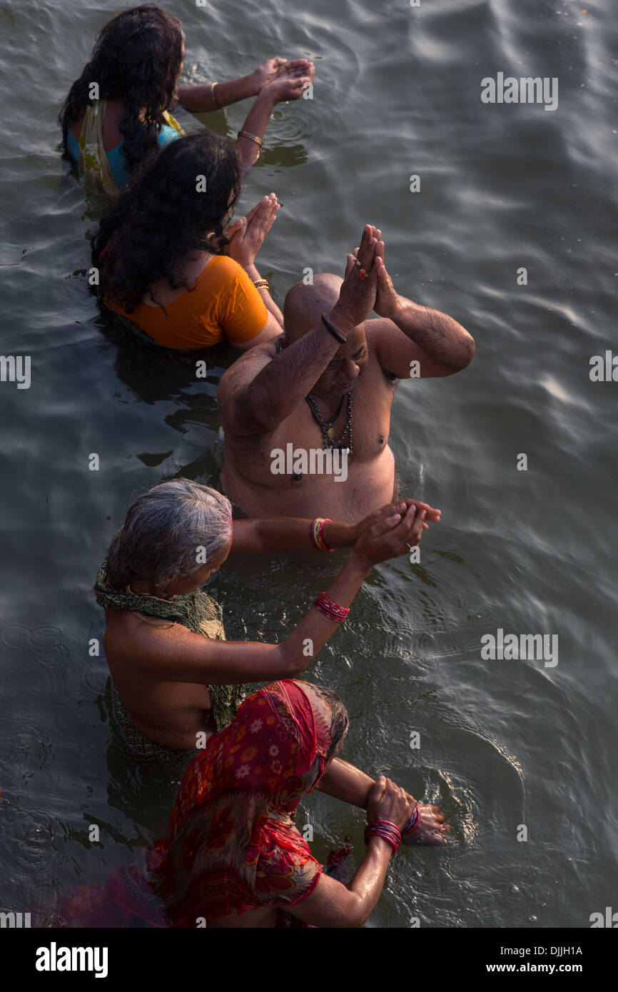A group of Hindu believers pray at dawn submerged in the waters of the ...