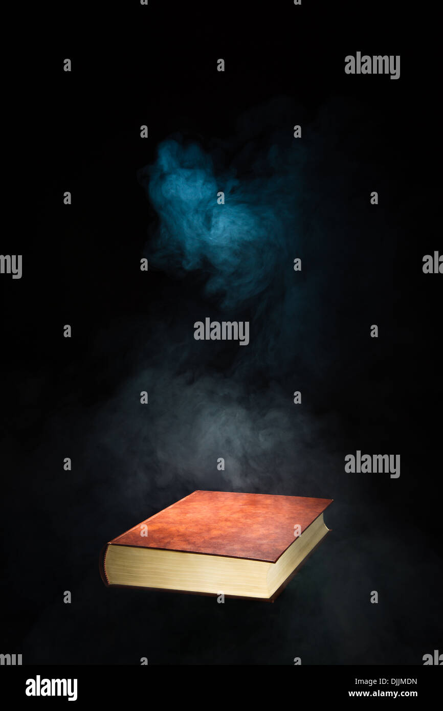 Floating unopened book and smoke, dark background Stock Photo - Alamy