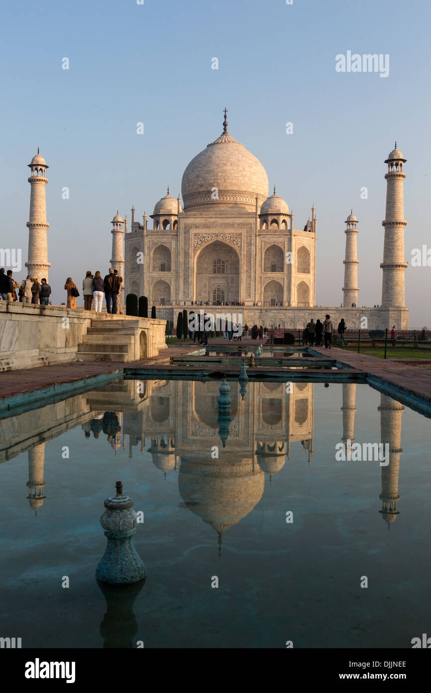 View of Taj Mahal at sunrise reflected on the water of one of the small ...