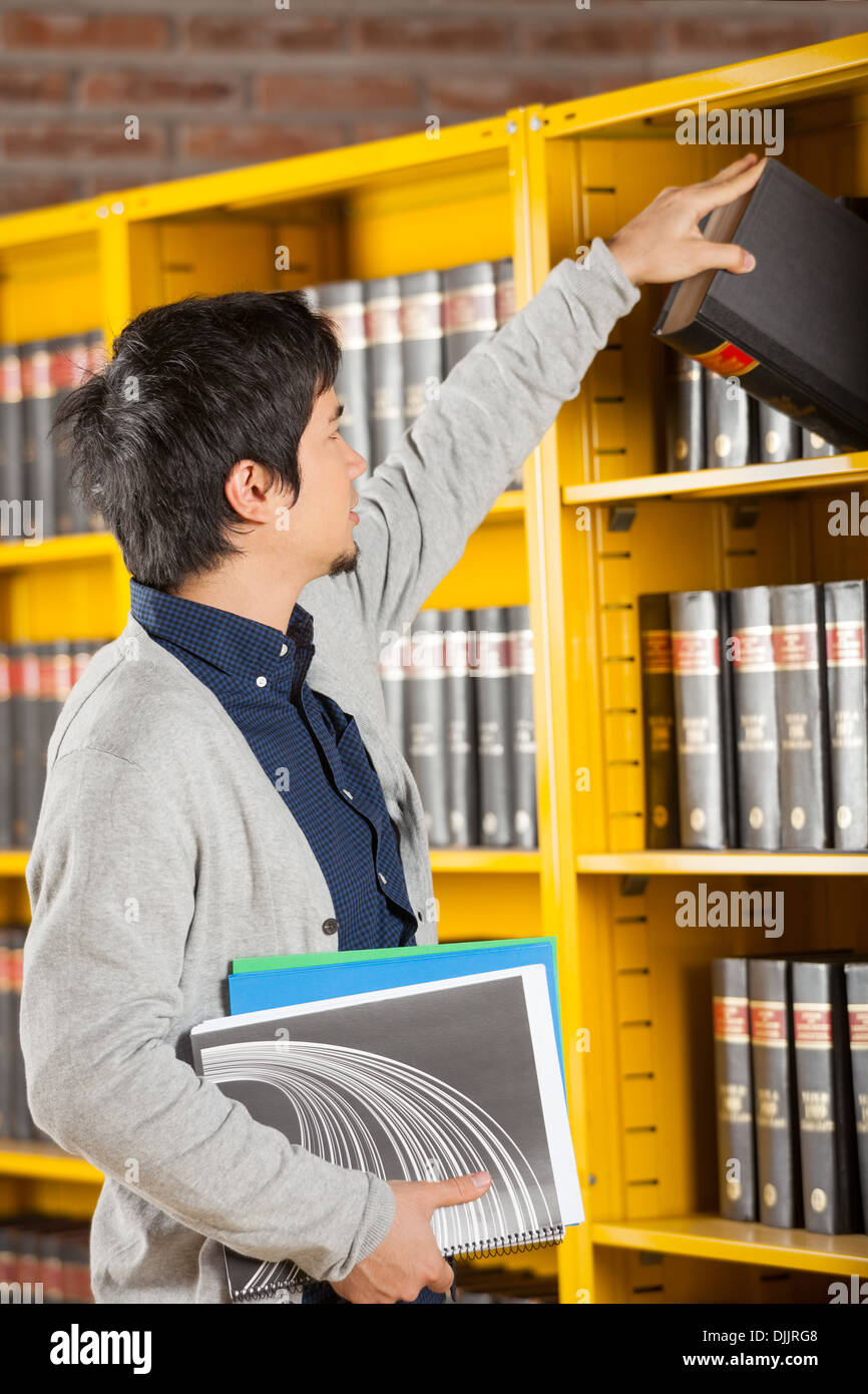 Student Taking Book From Shelf In University Library Stock Photo - Alamy
