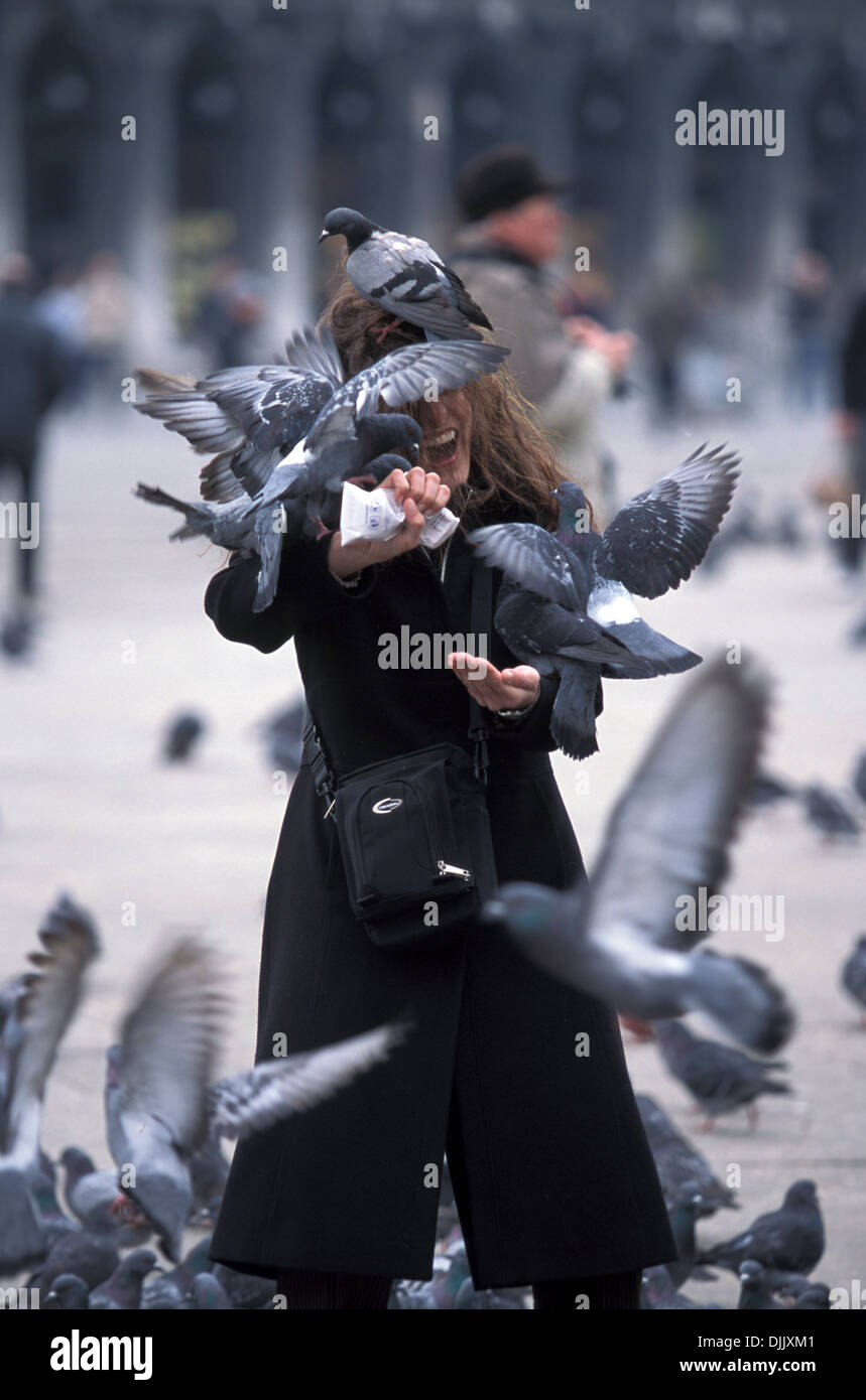 Scaring girl feeding pigeons in Piazza di San Marco, St Mark's Square ...