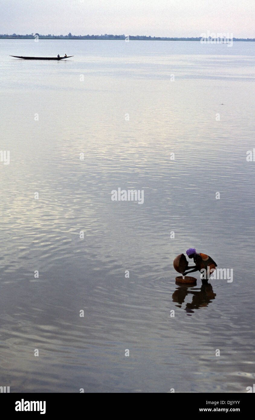 Woman washing in River Nicer with a traditional boat in Mali Stock ...