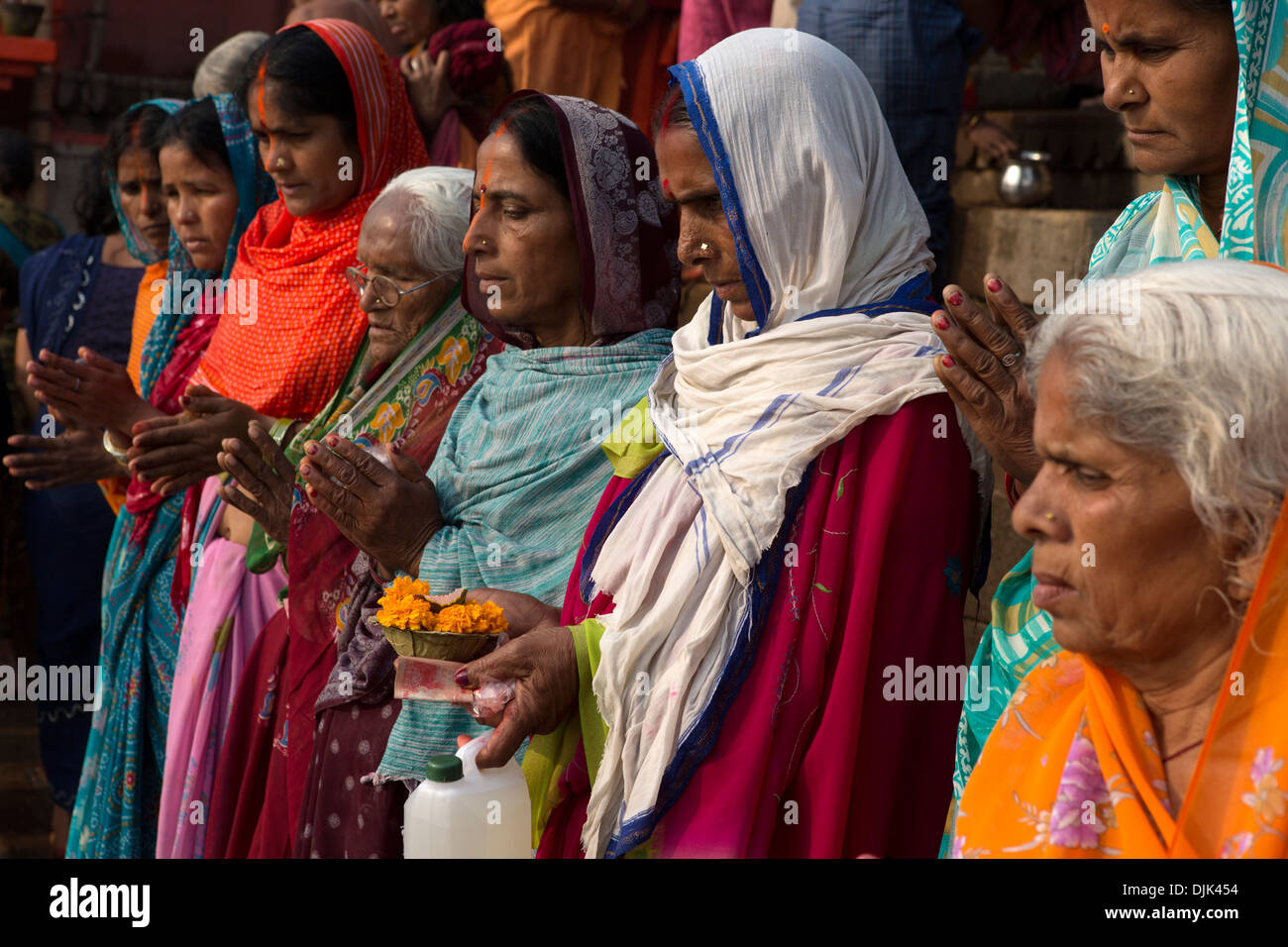 A group of Hindu women pray at dawn at the banks of the Ganges river in ...