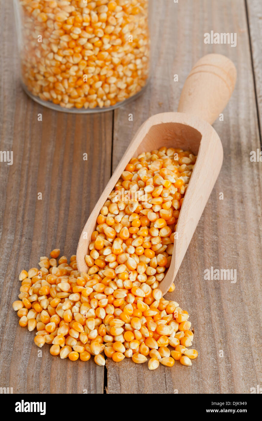 Dried corn kernels in wooden scoop on wood background Stock Photo - Alamy