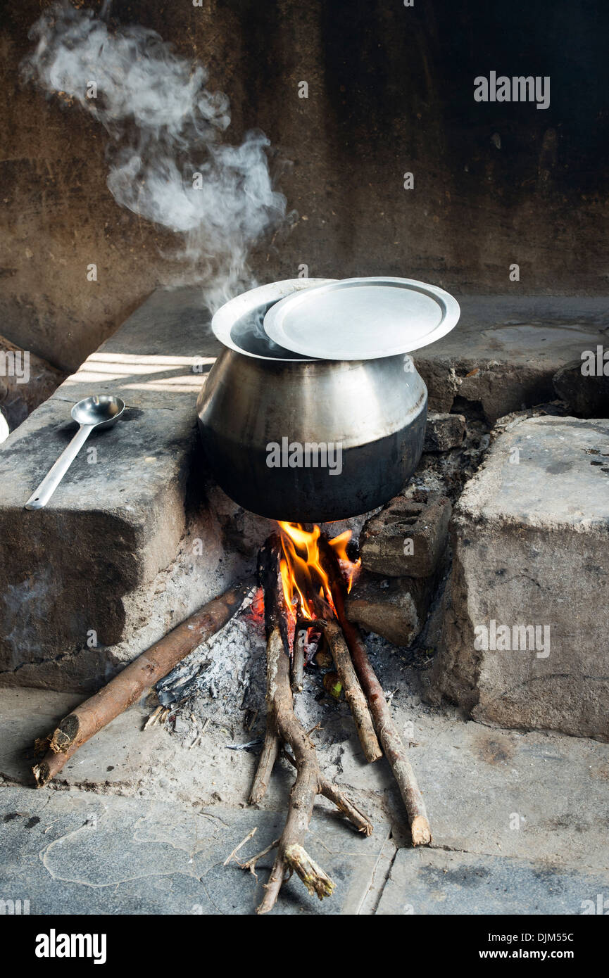 Cooking Rice in a pot on an outside fire next to a rural indian house ...