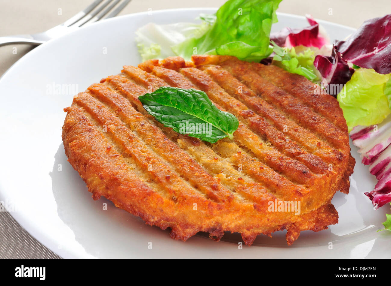 a veggie burger in a plate on a set table Stock Photo - Alamy