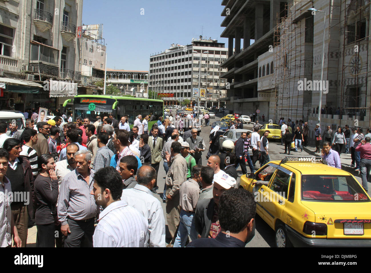 Syrians hold up national flags and posters of Syrian President Bashar ...