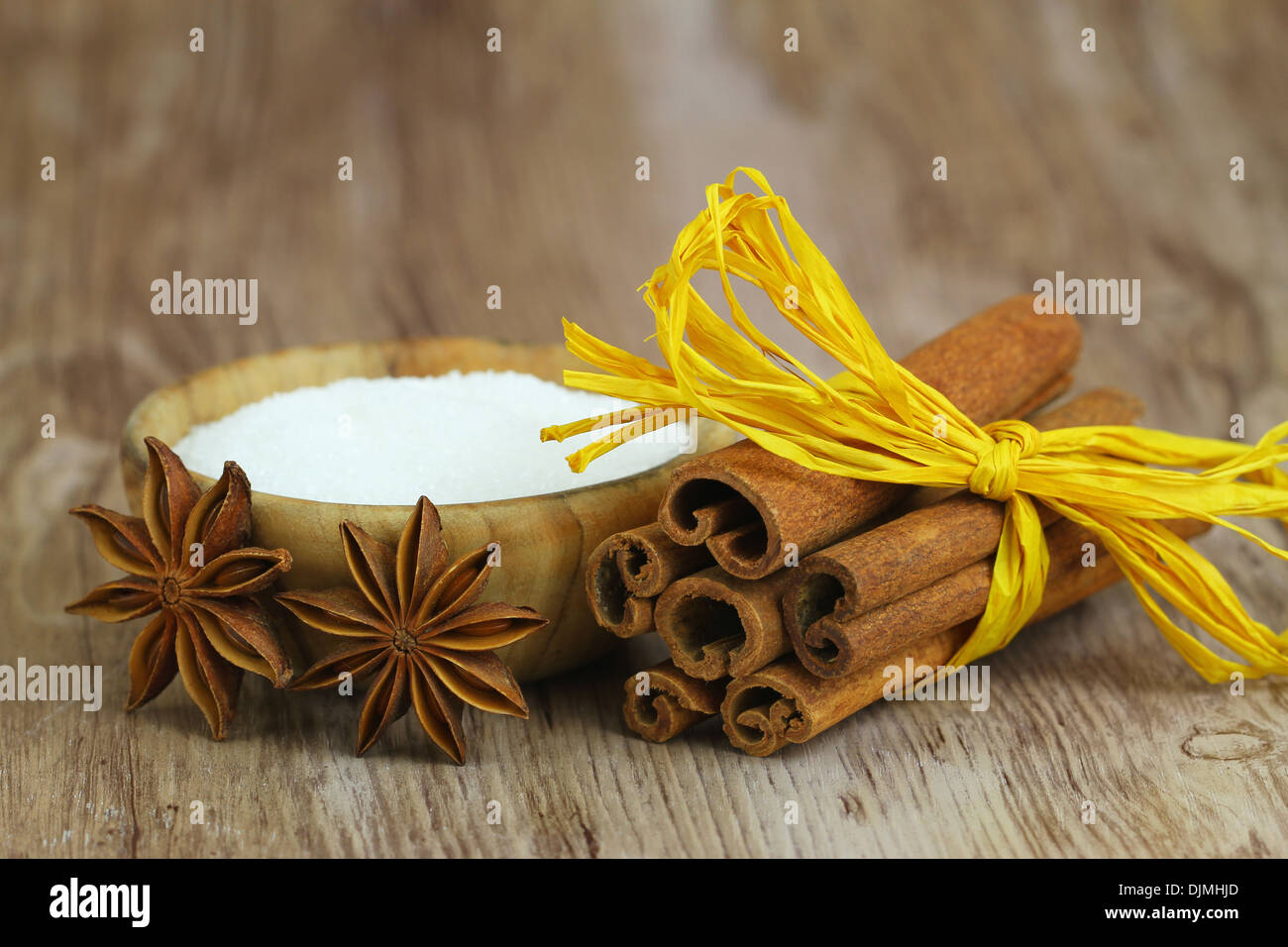 Star anise leaning against cinnamon sticks tied with yellow string ...