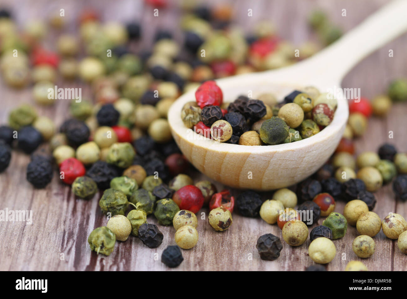 Mixed peppers on wooden spoon, close up Stock Photo - Alamy