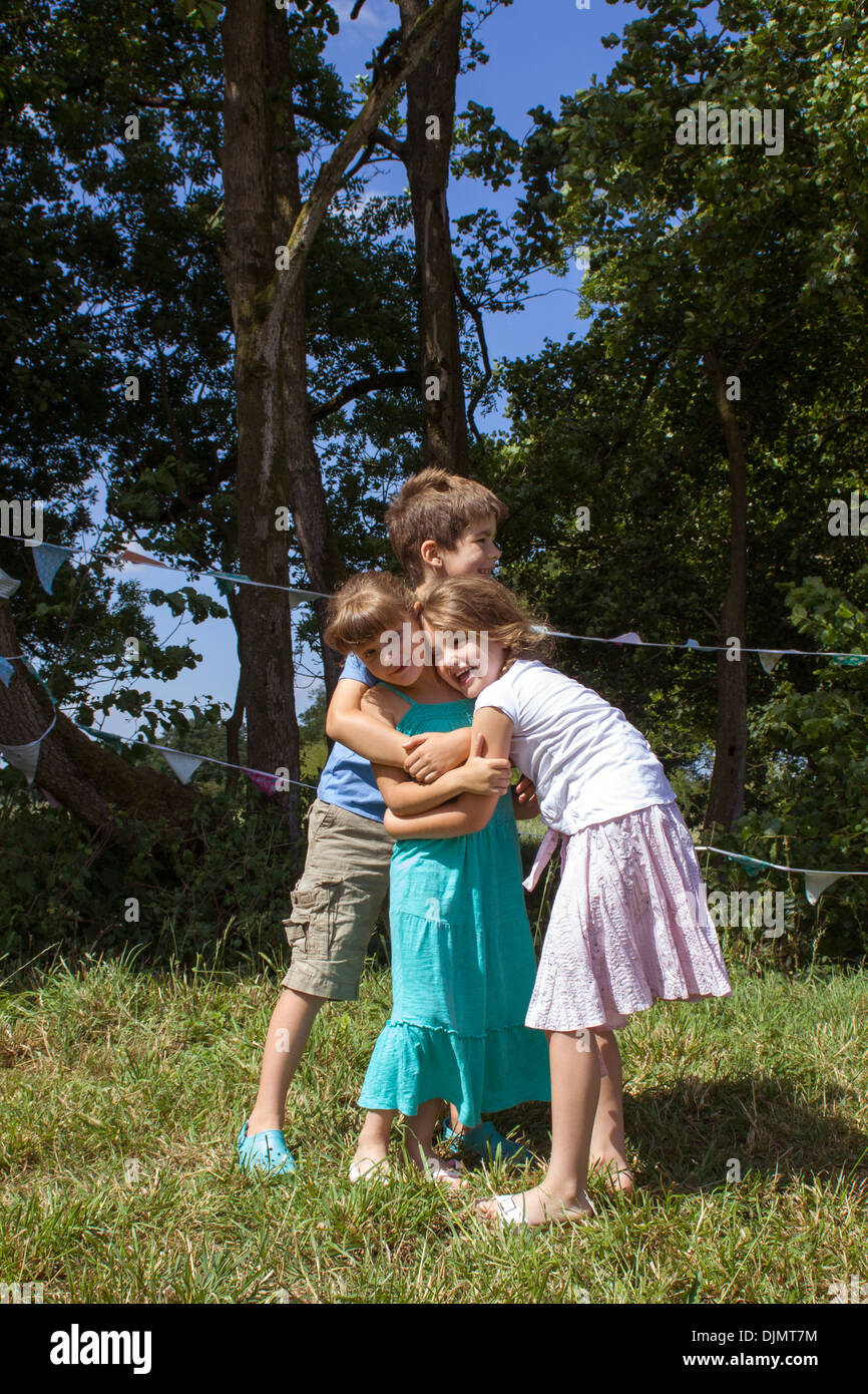 Children having a group hug on a picnic in the long grass in Somerset ...