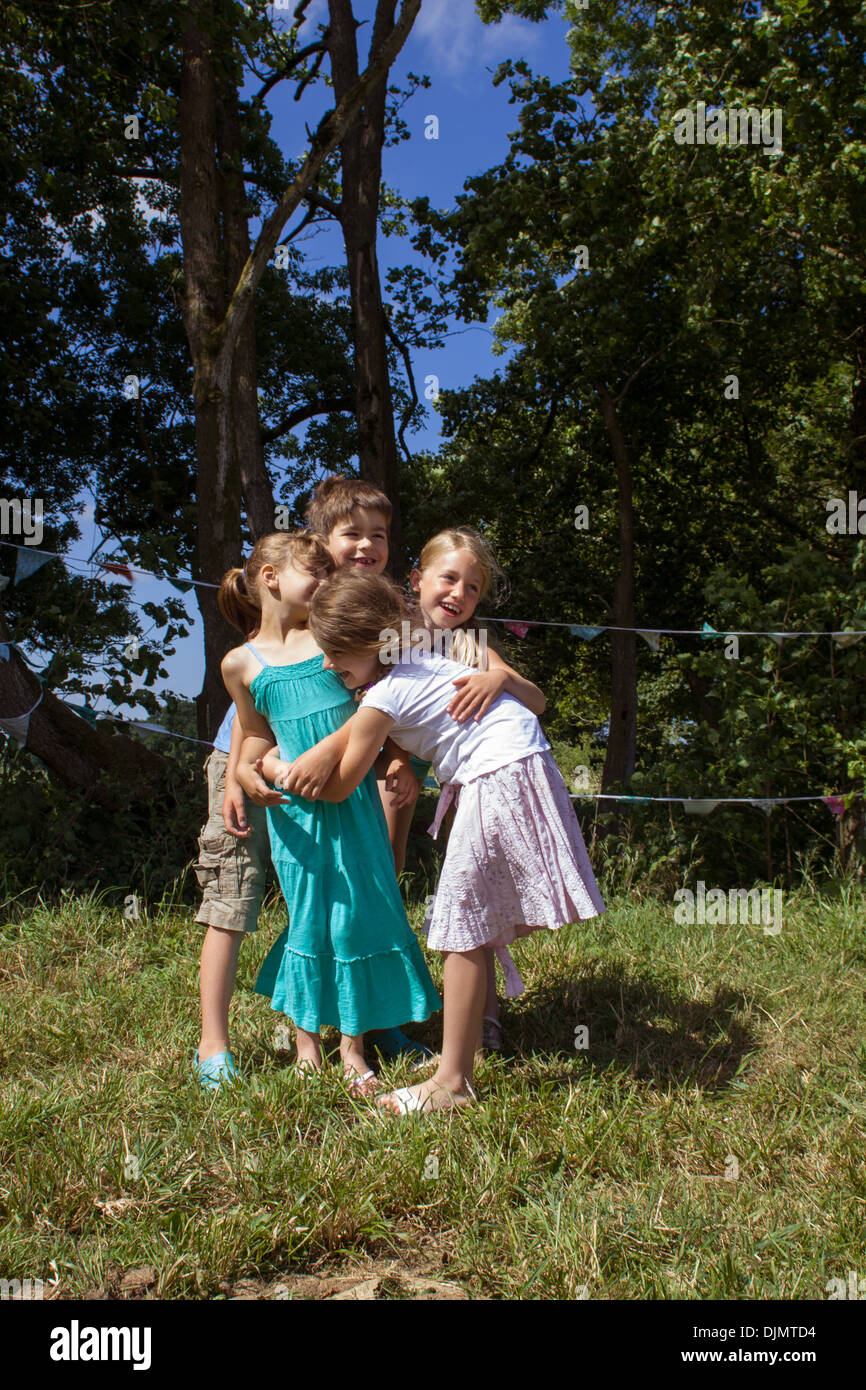 Children having a group hug on a picnic in the long grass in Somerset ...