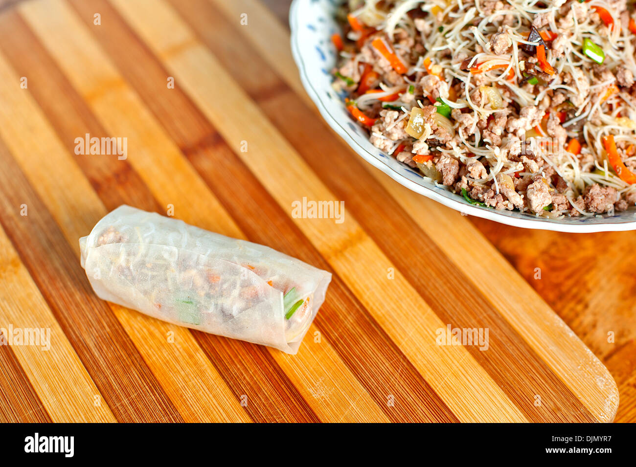 Revolute spring rolls at wooden desk Stock Photo - Alamy