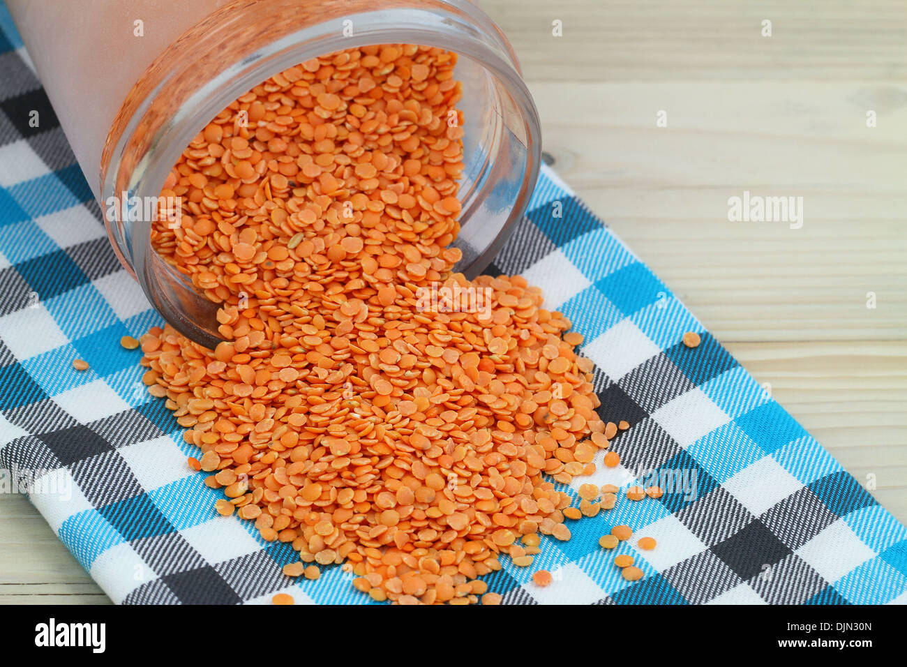 Scattered red lentils on checkered cloth, close up Stock Photo - Alamy