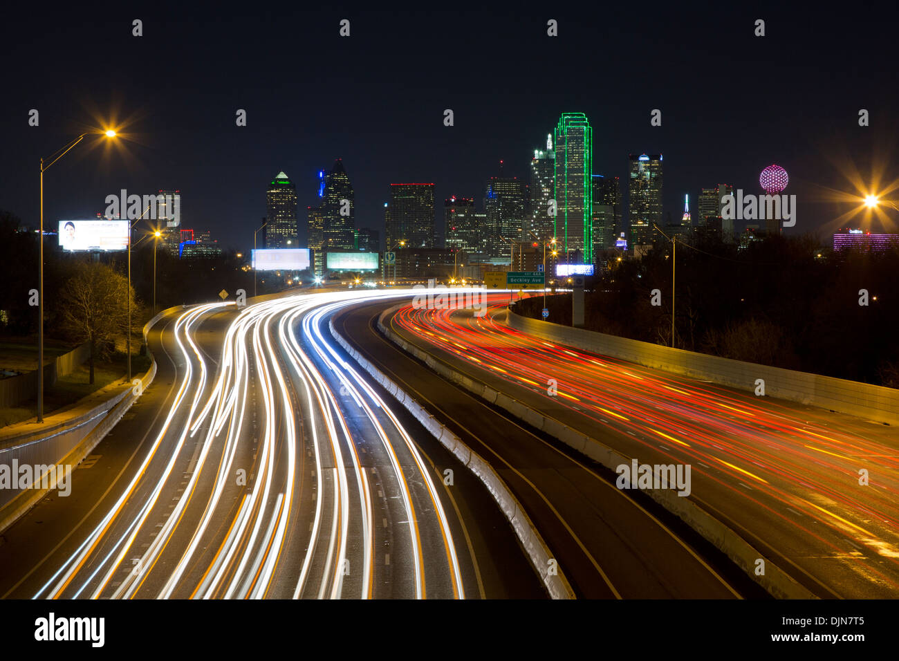 The Dallas skyline shines at night as traffic zooms by on Interstate 30 ...