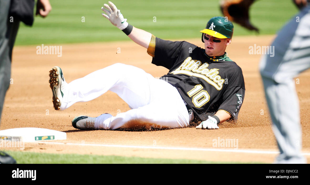 Oakland As Daric Barton slides safely into third base after hitting a ...