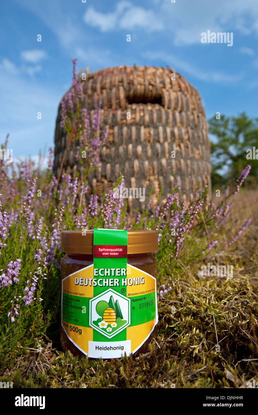 Honey jar and old beehive / skep for honeybees at apiary in the ...