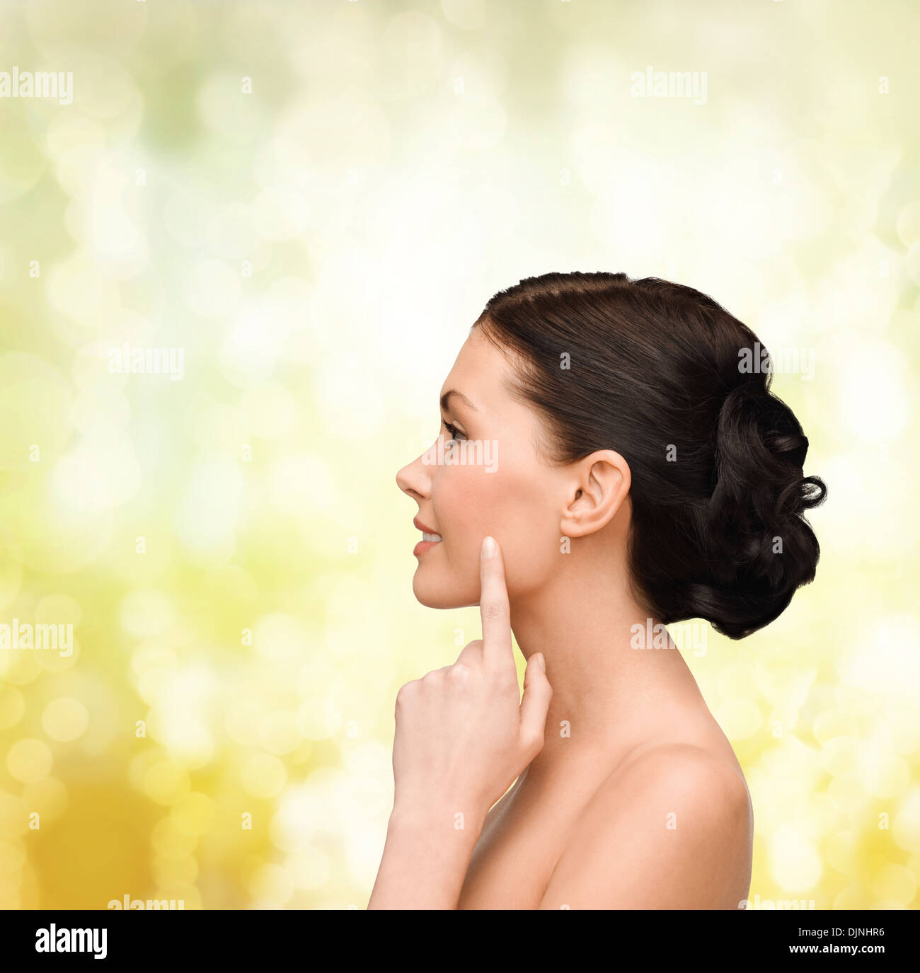 smiling young woman pointing to her cheek Stock Photo - Alamy
