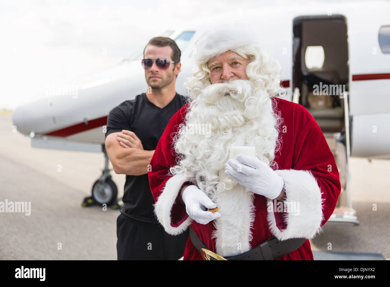 Santa Holding Milk Glass By Bodyguard Against Private Jet Stock Photo ...