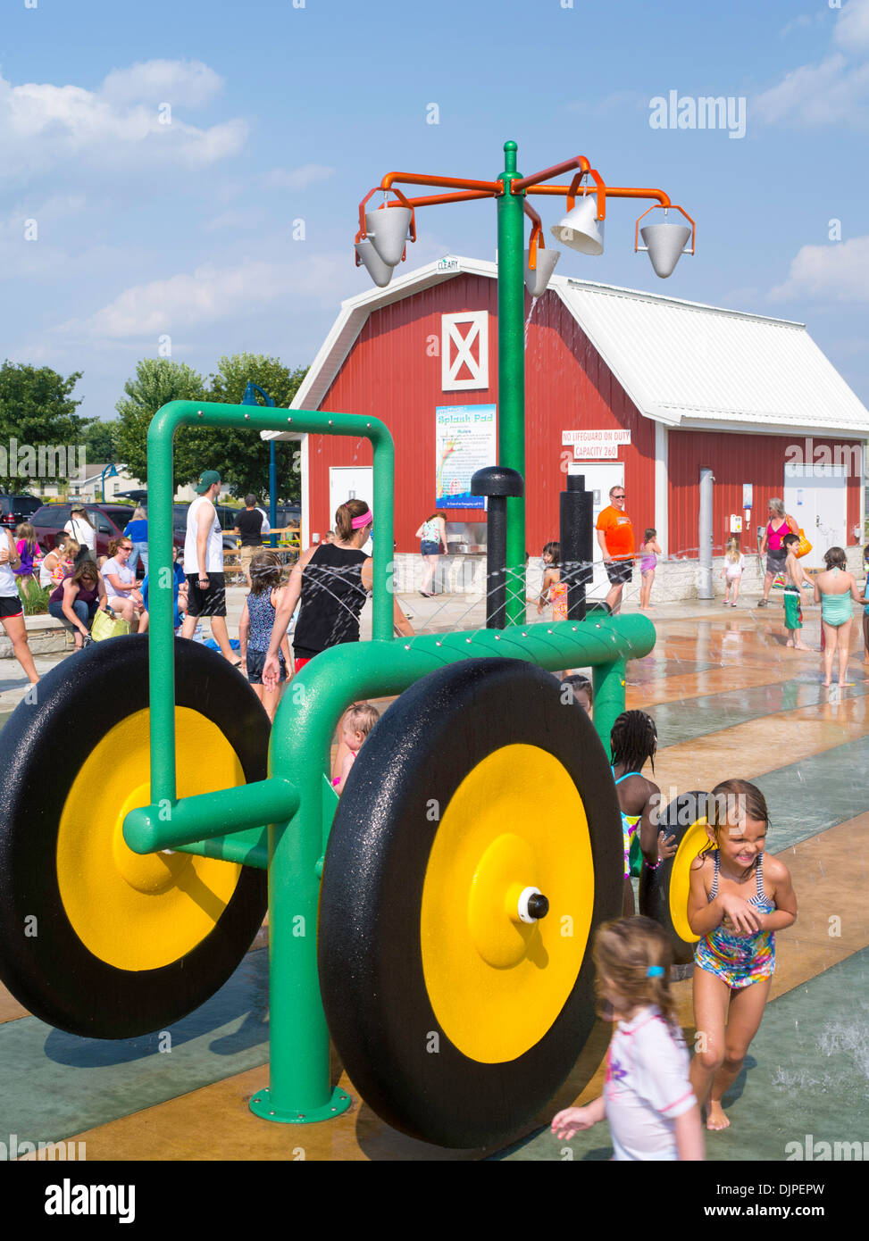 Children and adults play at the new Splash Pad located at McKee Farms ...