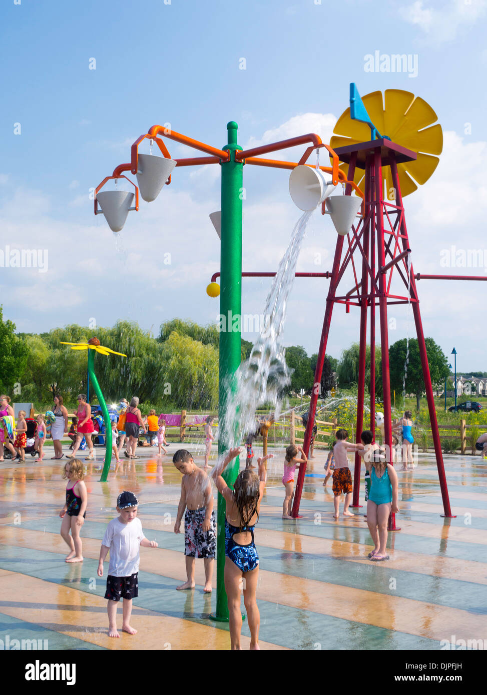 Children and adults play at the new Splash Pad located at McKee Farms ...