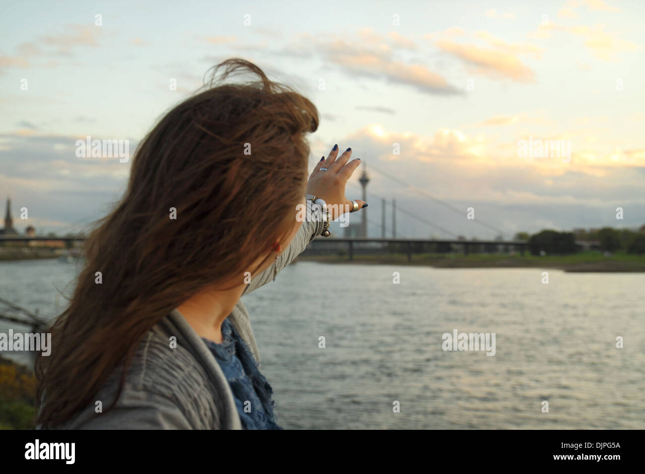 Woman reach out for a tower in the skyline of a town Stock Photo - Alamy