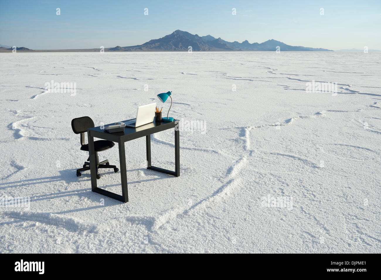 Business desk and empty office chair stand outdoors in dramatic white ...