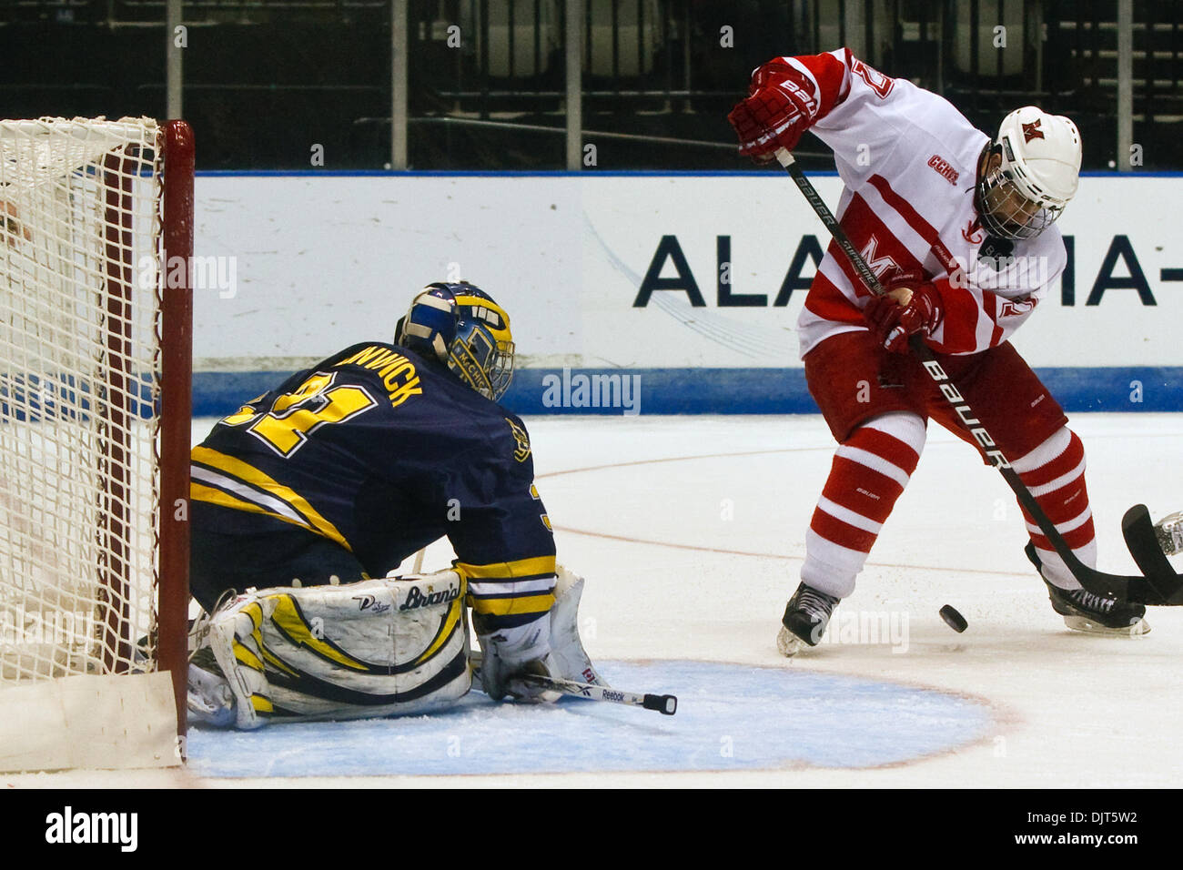 Miami center Andy Miele (17) tries to score against Michigan goaltender ...