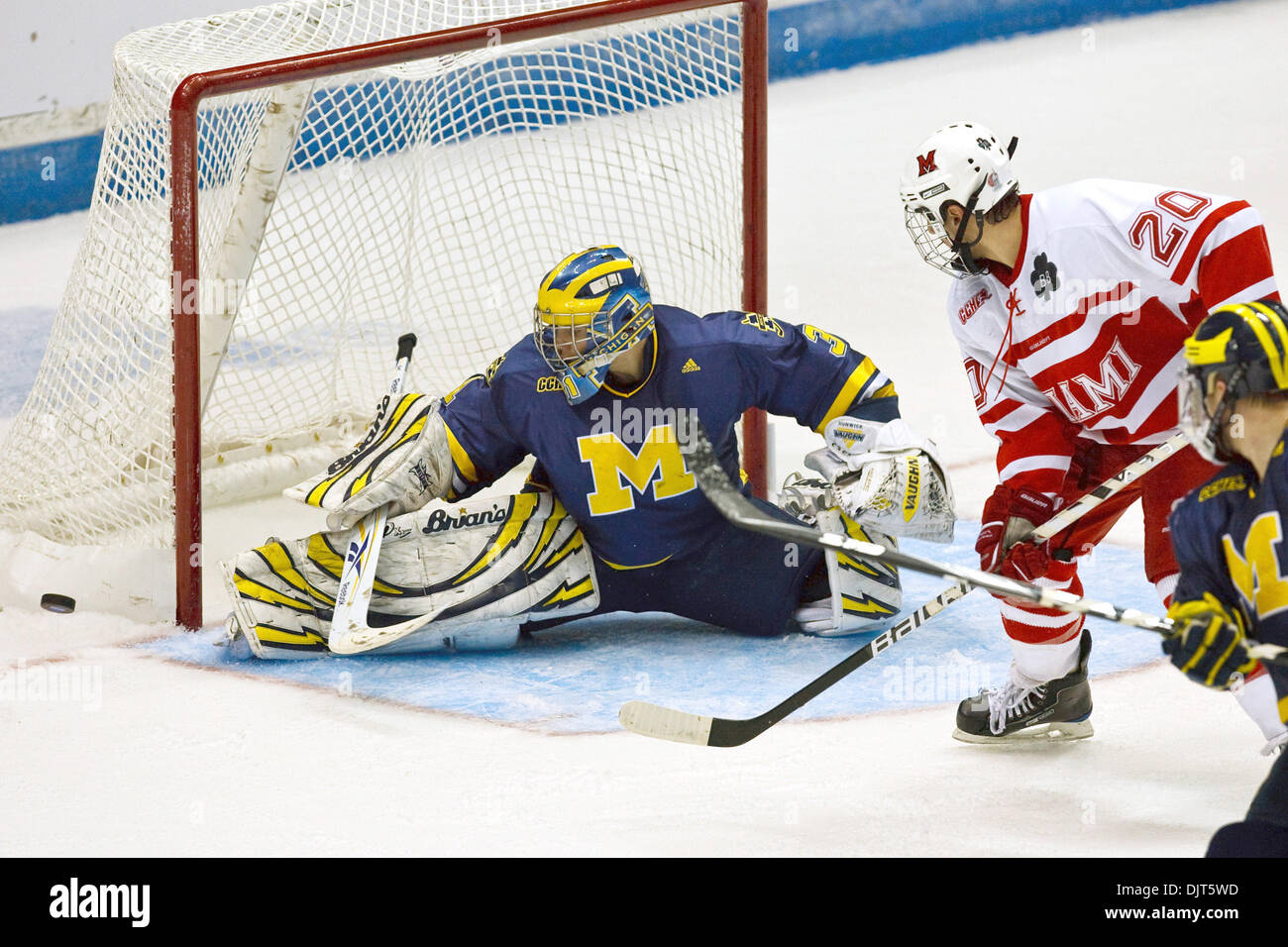 Michigan goalie Shawn Hunwick (31) blocks a shot by Miami center Pat ...