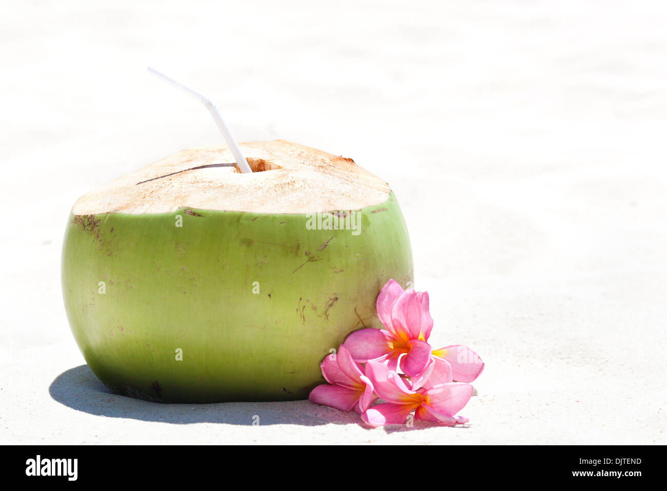Tropical fresh coconut cocktail decorated plumeria on white beach Stock ...