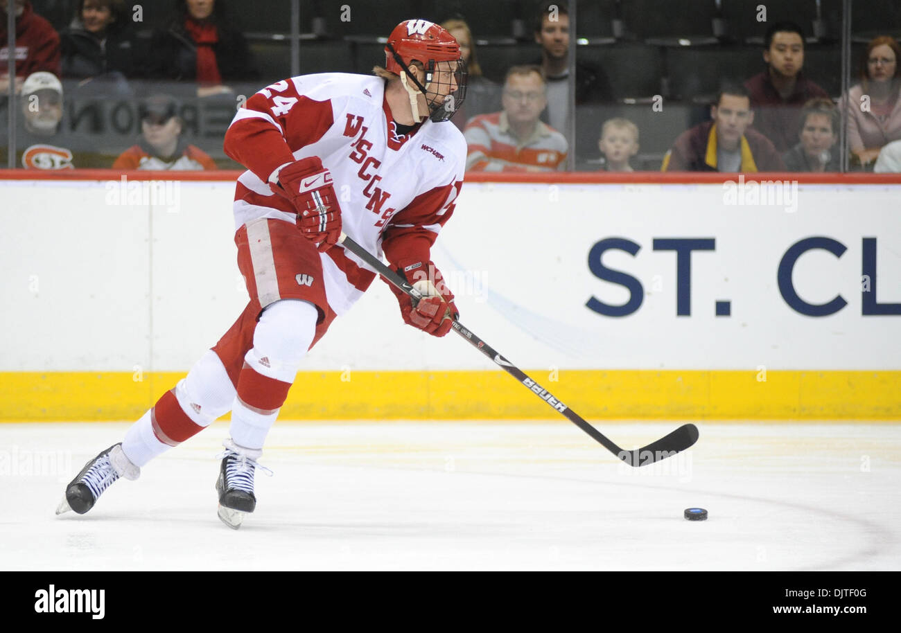 John Mitchell #24 of the Wisconsin Badgers brings the puck out of the ...