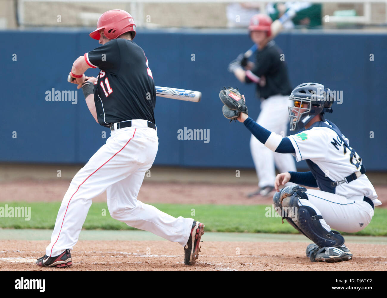 St. John's third baseman Greg Hopkins (#11) and Notre Dame catcher ...
