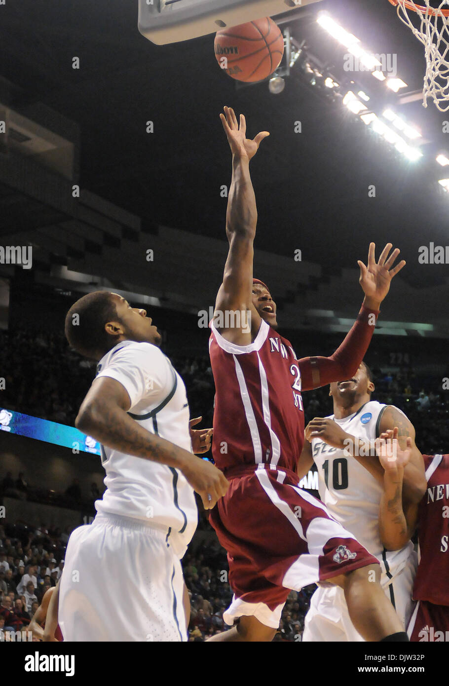 New Mexico State's guard Jonathan Gibson, center, puts up a shot over ...