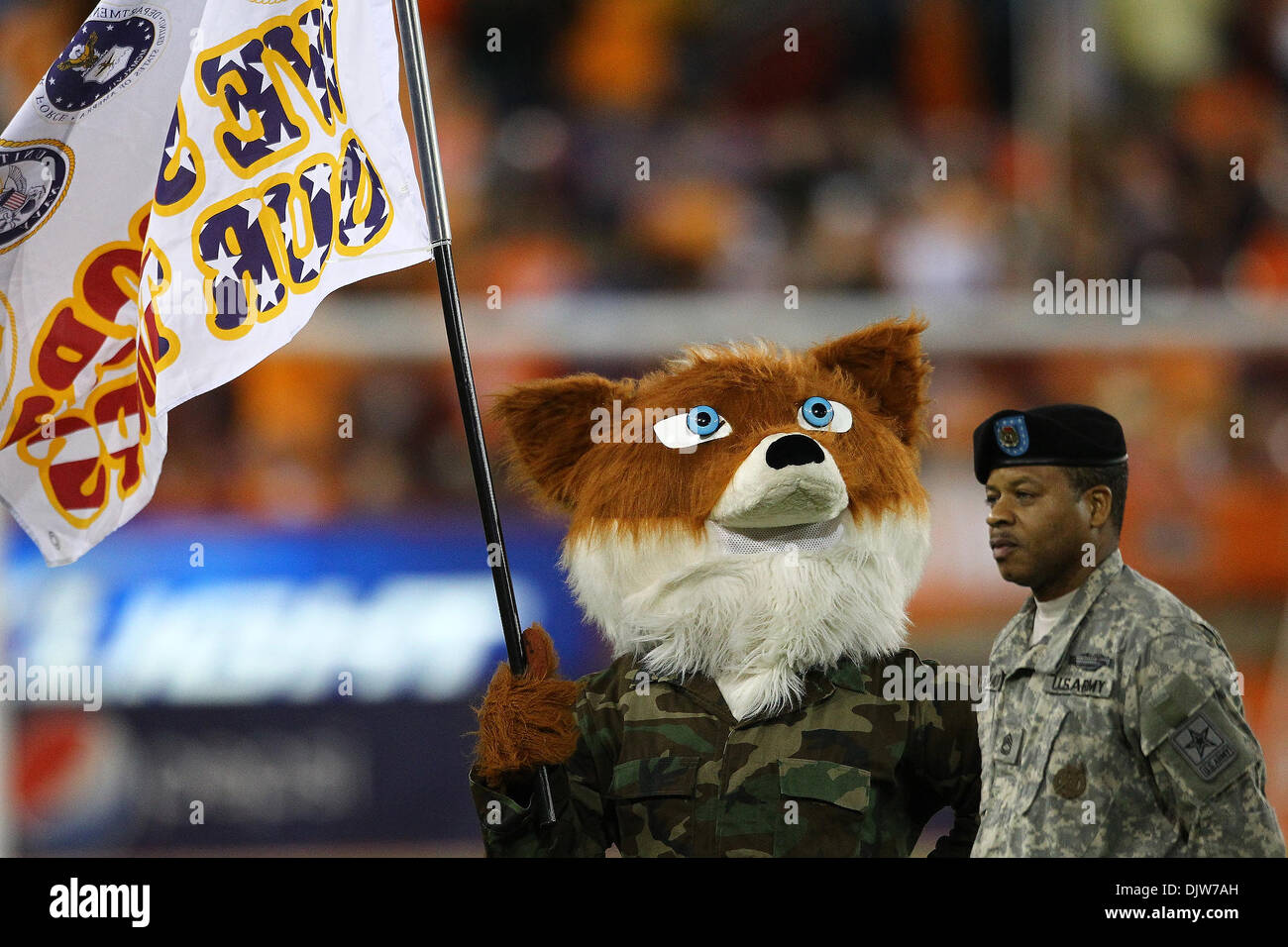 The Houston Dynamo Mascot stands with an honored Army sergeant, holding ...