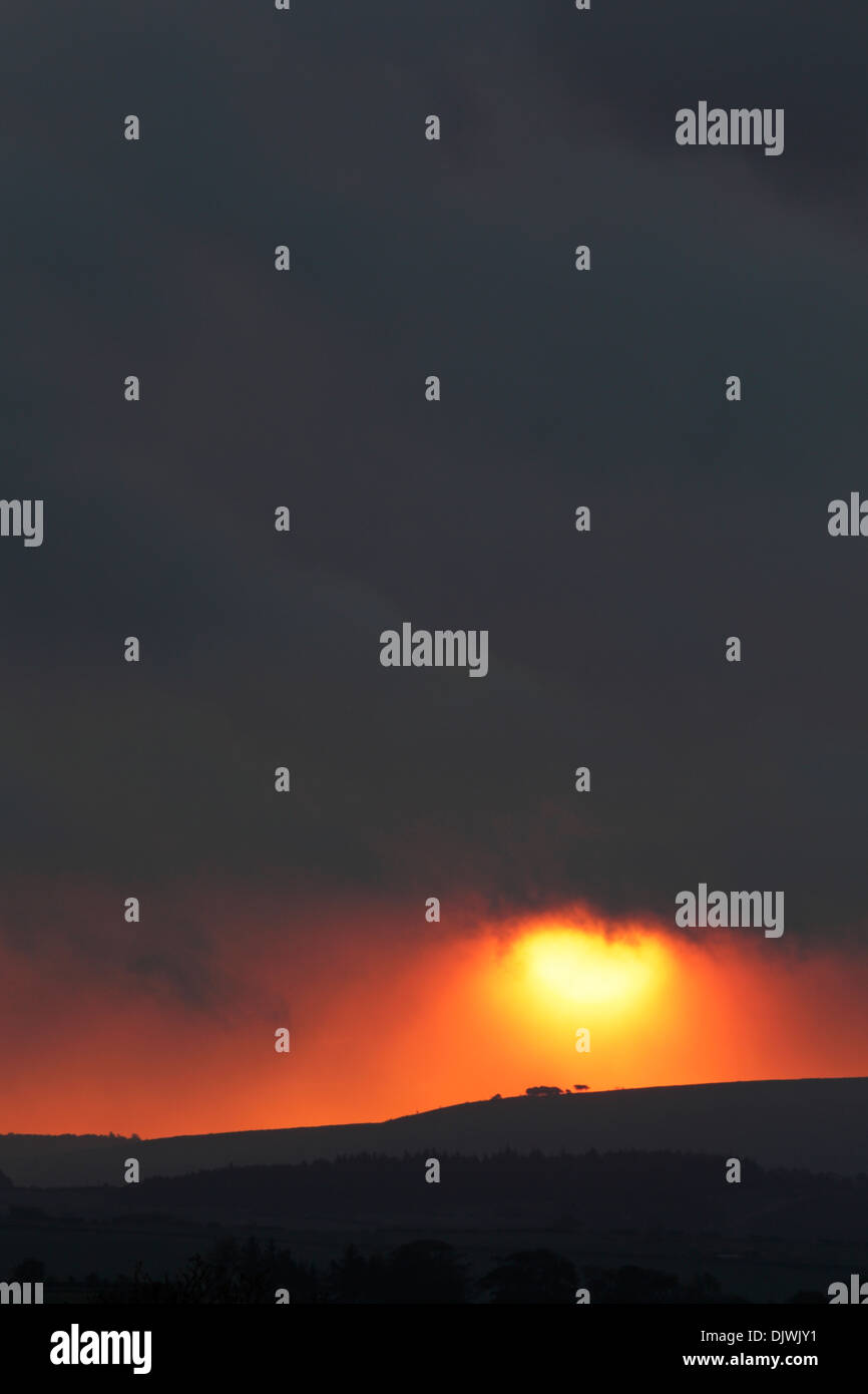 Sun rising over rolling hills into a colourful fiery stormy sky Stock ...